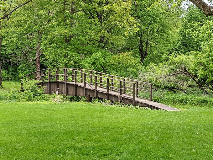 This wooden footbridge seems plucked from a storybook, inviting visitors to cross into moments of quiet reflection.