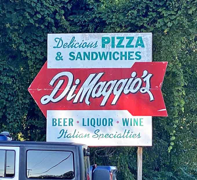 The vintage roadside sign points the way to pizza paradise, a charming relic from an era when signs were works of art.