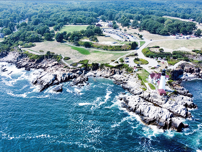 An aerial perspective reveals Portland Head Light's strategic position, the white tower standing proud against Maine's emerald coastline.