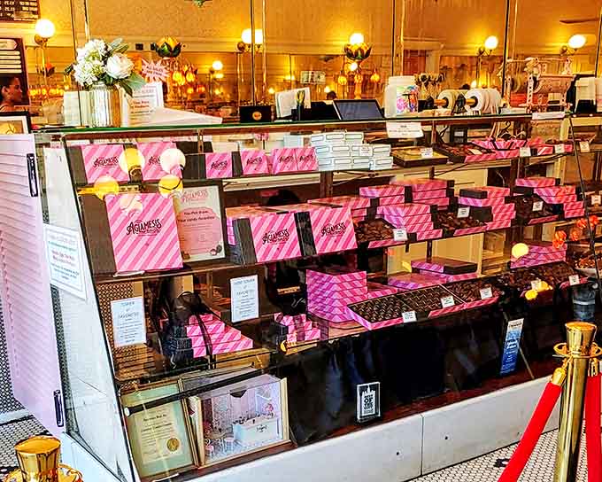 Signature pink boxes stacked neatly on shelves promise sweet treasures within &ndash; the perfect gift for someone special or yourself.