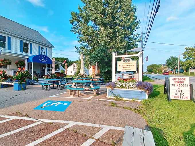 Turquoise picnic tables, colorful planters, and a welcoming sign create an outdoor dining area that's perfect for summer evenings in the islands.