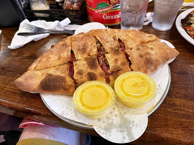 This isn't just a calzone &ndash; it's a golden-brown treasure chest filled with molten cheese and fillings that make sharing nearly impossible.