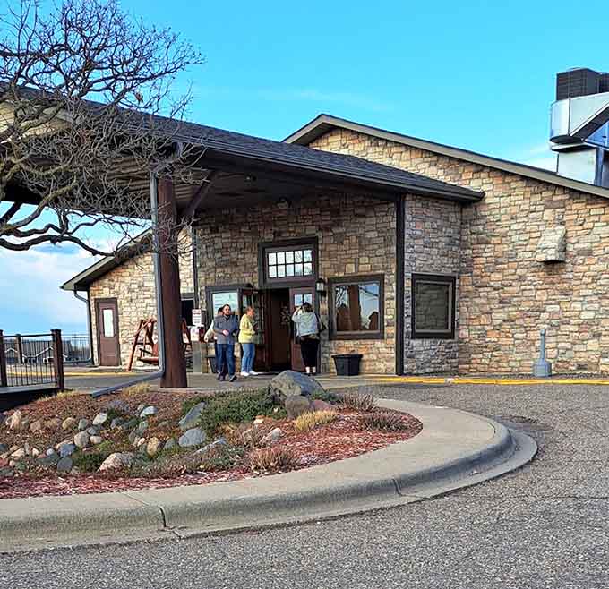 The entrance welcomes guests with prairie landscaping and stone architecture, setting expectations for the quality experience waiting inside.