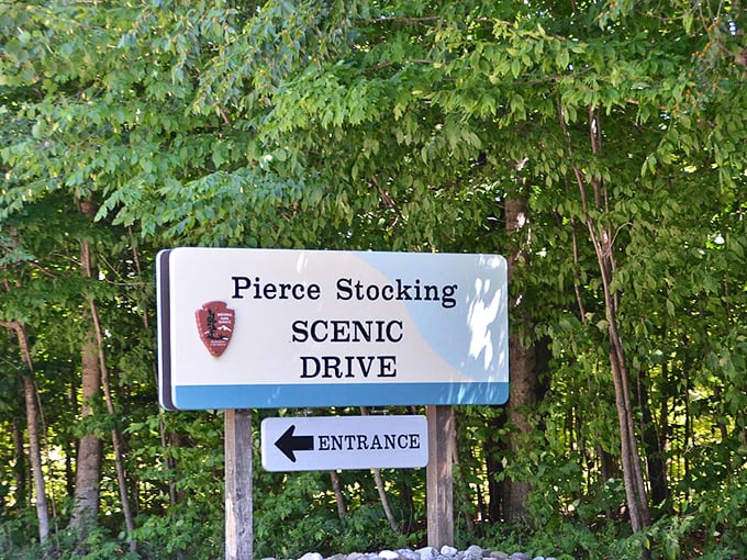The Pierce Stocking Scenic Drive sign points the way to Michigan's most photogenic road trip, where every turn delivers on its scenic promises.