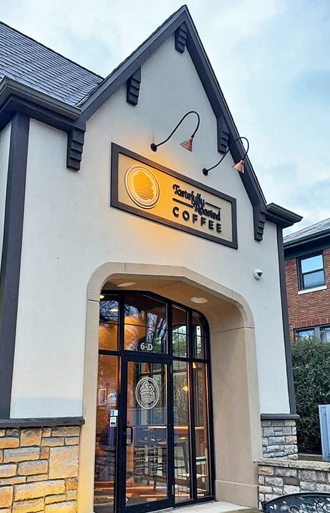 As evening approaches, the illuminated entrance glows like a beacon for those seeking one last perfect cup before day turns to night.