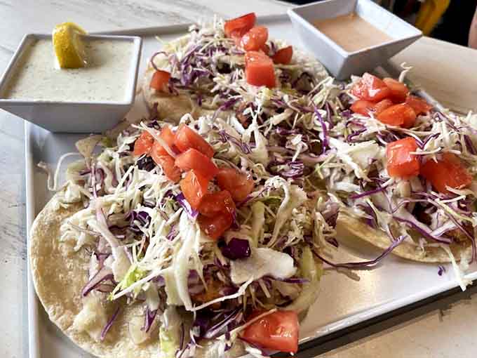 These fish tacos showcase the bounty of local waters &ndash; tender fish nestled in soft tortillas, topped with crisp slaw and fresh tomatoes that taste like summer itself.