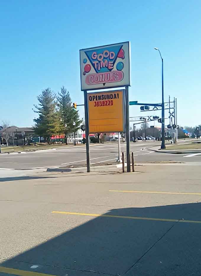 The roadside sign stands as a beacon of hope for the hungry and donut-deprived. Follow it to find your way to frosted happiness.
