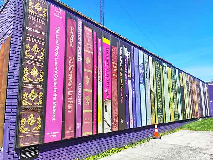 The stunning trompe l'oeil mural depicting book spines creates an outdoor gallery that celebrates literature even before you step inside.
