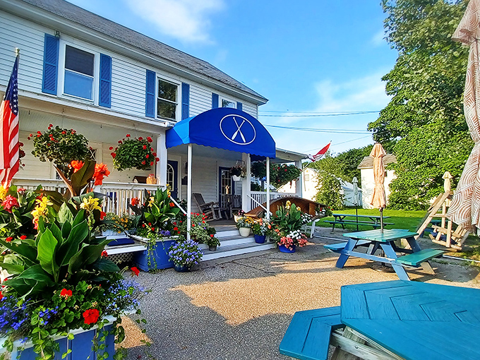 The entrance in summer glory &ndash; flowers, sunshine, and the promise of culinary magic waiting just beyond those doors.