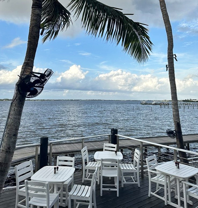 Between swaying palms, the St. Lucie River stretches to the horizon&mdash;nature's perfect backdrop for an unforgettable meal.