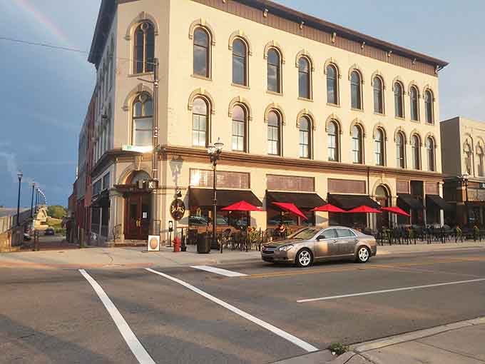 Red umbrellas dot the outdoor seating area, offering al fresco dining with a view of downtown Saginaw's architectural charm.