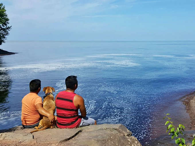 Simple moments become profound memories at Lake Superior's edge, where companions share the peaceful beauty of Michigan's wildest shoreline.
