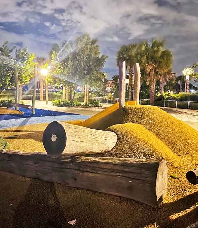 As the day transitions to evening, the playground's sandy mounds and palm trees create a tranquil backdrop for the final adventures of the
