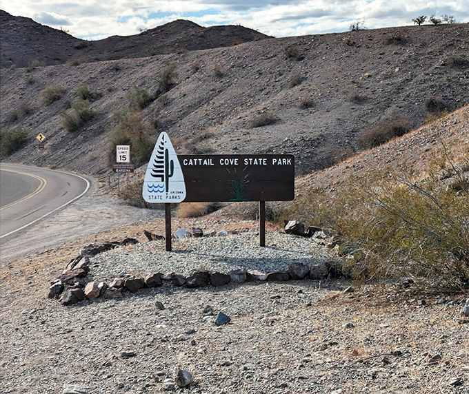 The park's entrance sign stands against rugged terrain, a promise of water and wonder just around the bend.