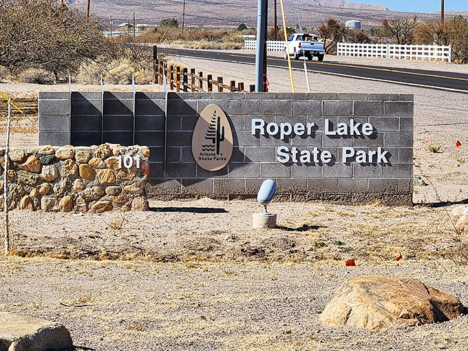 The entrance sign promises adventure beyond, standing sentinel between everyday life and the natural escape that awaits just down the road.