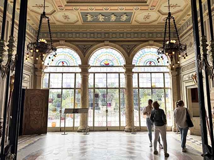 Stained glass transforms ordinary sunlight into jewel-toned magic, casting colorful shadows across marble floors where visitors now tread.