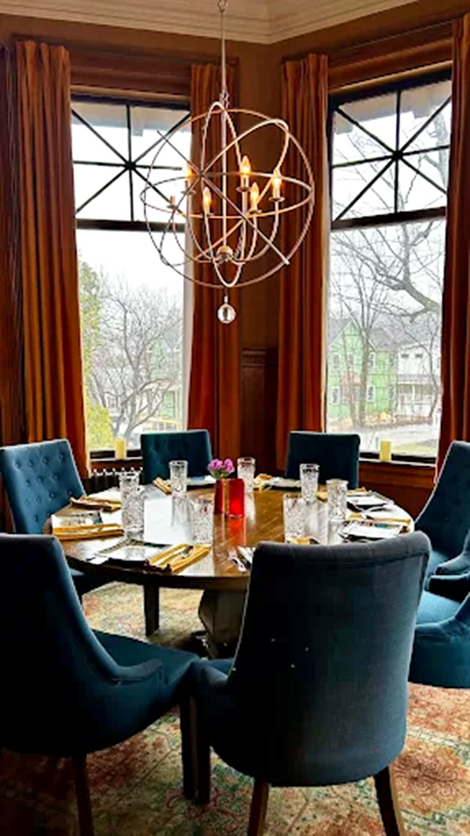 The window table where food meets ambiance in perfect harmony. Those blue chairs have witnessed more romantic proposals than a jewelry store.