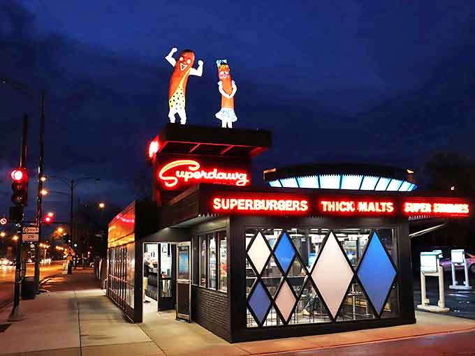 At night, Superdawg transforms into a neon wonderland, its glowing signs and mascots creating a magical beacon for late-night food adventurers.