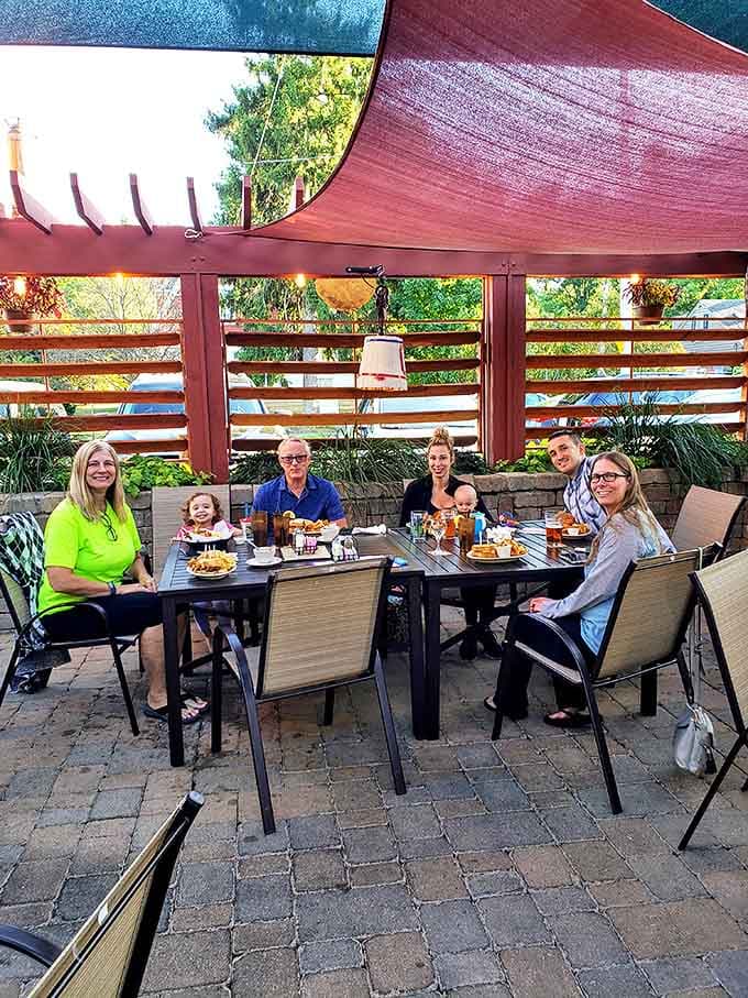 The outdoor patio where summer evenings stretch pleasantly into night under shade sails, with happy diners enjoying good food and even better company.