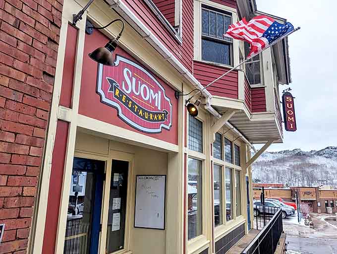 The entrance to Suomi, with its vintage sign and American flag, offers a simple promise: authentic food awaits within these walls.