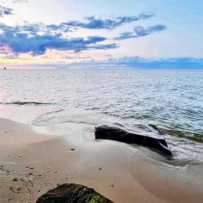 Lake Huron's gentle waves lap against a sandy beach at sunset, where the day's adventures give way to peaceful reflection.