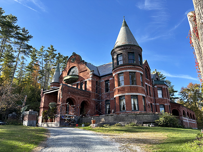 The castle's distinctive turret and red brick façade stand against Vermont's blue sky like an architectural exclamation point in the Green Mountain landscape.
