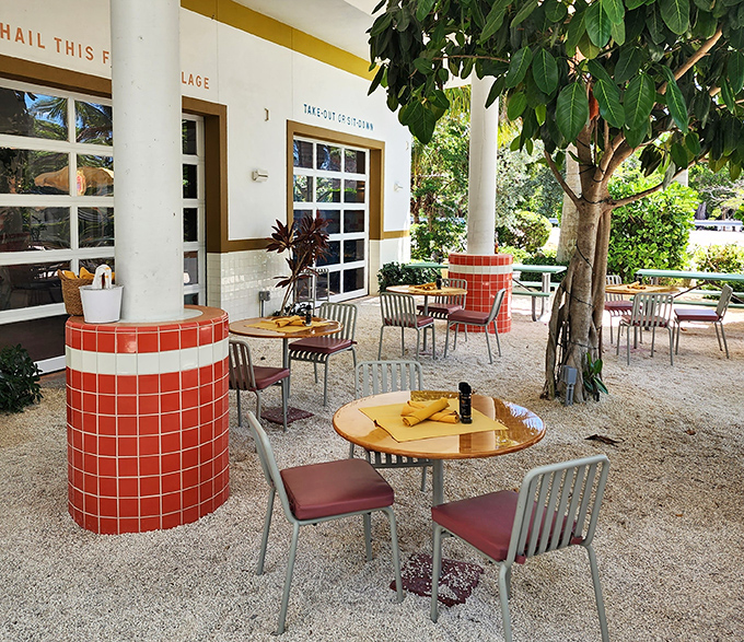 Whitney's outdoor dining area feels like a secret garden – red-tiled columns and vintage umbrellas create a retro-tropical paradise.