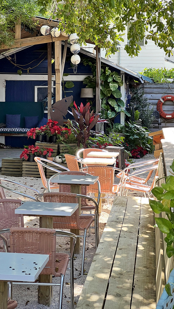 The outdoor seating area offers a tranquil spot to enjoy Gulf breezes, with lush plants providing natural shade for alfresco dining.