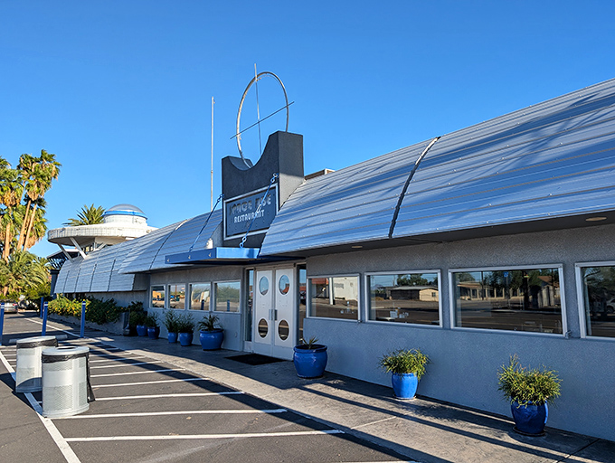 The restaurant's curved metallic exterior with porthole windows completes the spaceship aesthetic, making it an unmissable landmark on the Arizona highway.
