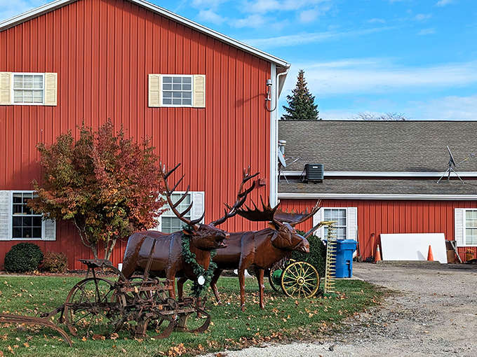 Metal moose sculptures pull an antique farm implement outside the red barn, creating an eye-catching display that stops traffic on M-43.