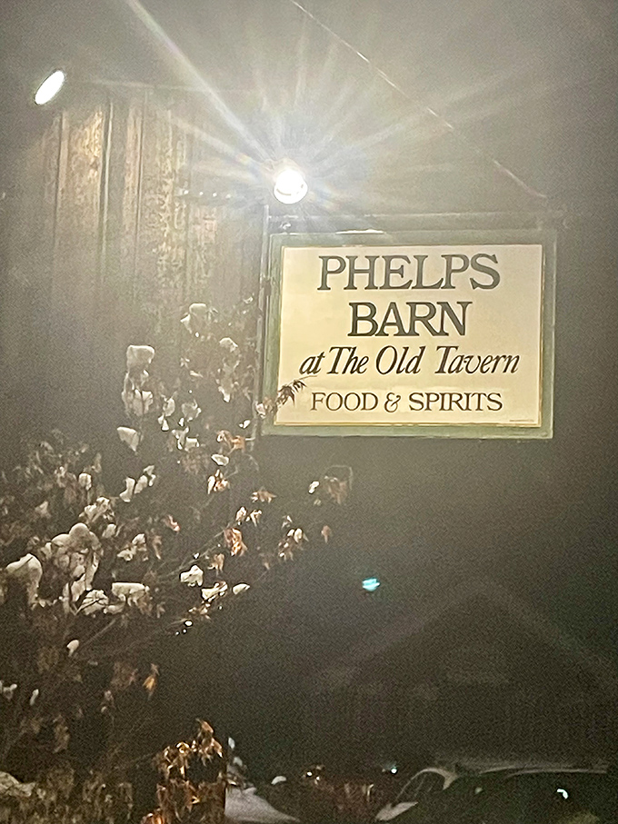 Evening transforms Phelps Barn into a glowing beacon of hospitality, where the illuminated sign promises memorable meals and Vermont warmth to all who enter.