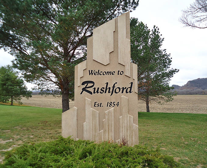 The "Welcome to Rushford" sign stands as a modest introduction to a town that consistently exceeds expectations once you arrive.