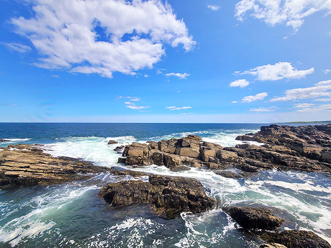 Nature's raw power on display – Atlantic waves crash against ancient rocks, creating the dramatic seascape that makes Portland Head Light so captivating.