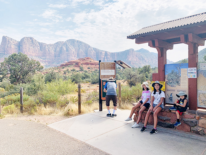 Young adventurers rest at a trailhead shelter, gathering energy for discoveries that no video game could possibly match.