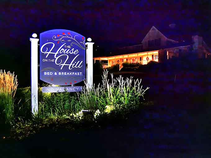 As darkness falls, the illuminated sign guides weary travelers to their destination &ndash; a beacon of hospitality glowing warmly against the night sky.