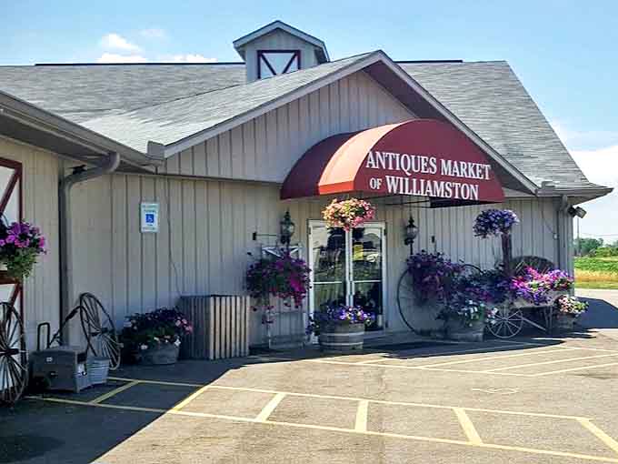 The welcoming facade of the Antiques Market of Williamston stands ready to transport visitors through time, with hanging flower baskets adding cheerful punctuation.
