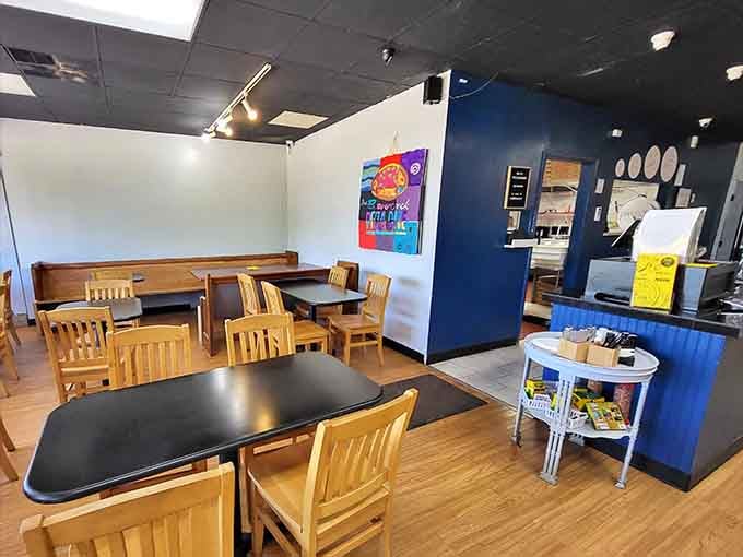Simple wooden tables and blue accent walls create a no-nonsense dining space where the pizza rightfully becomes the star of the show.