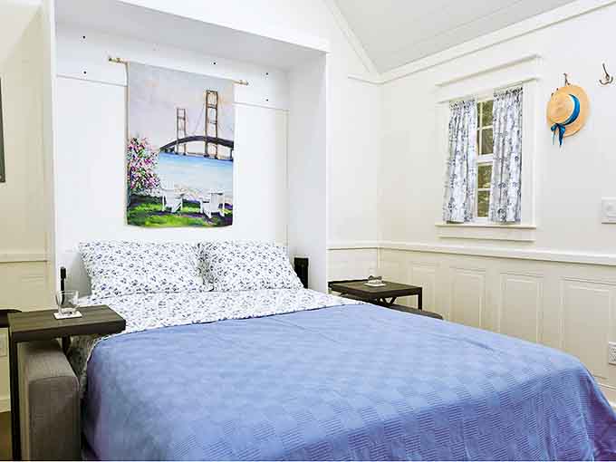 Drift off to dreams of Mackinac Bridge in this charming cabin bedroom, where Michigan's iconic landmark watches over your slumber.