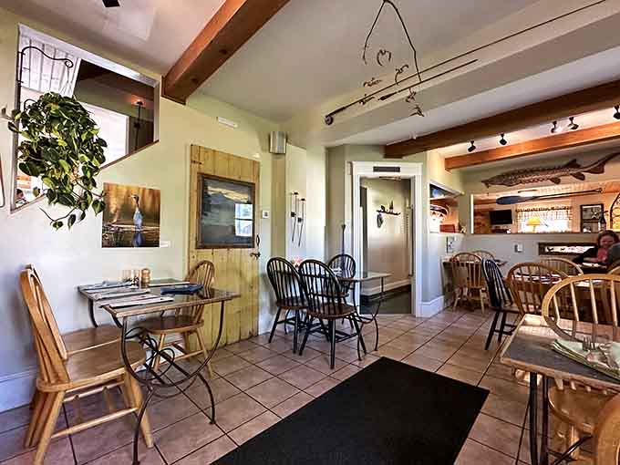 Exposed beams, eclectic seating, and whimsical fish art create a dining room that's equal parts cozy cabin and sophisticated bistro.
