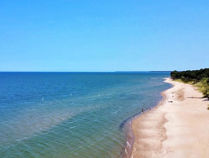 Pristine shoreline stretches into infinity, where Lake Huron's crystal waters create nature's own therapy session.