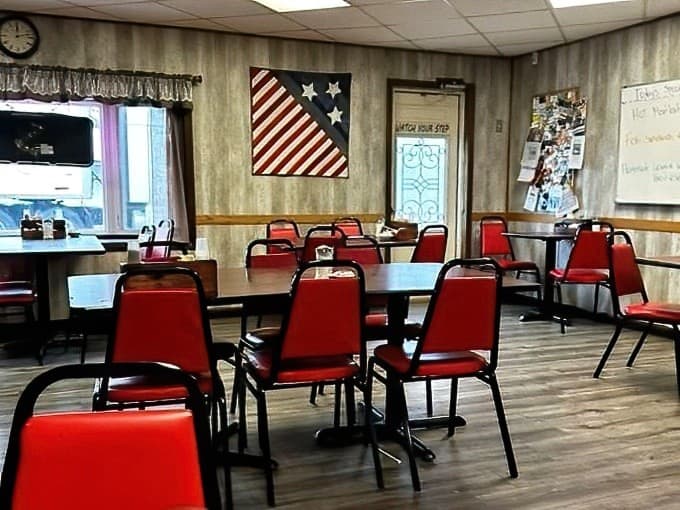 Red chairs and an American flag create that classic small-town diner atmosphere where conversations flow as freely as the coffee.