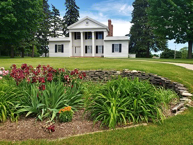 The stately Cotton House stands proudly amid manicured gardens, its classic columns whispering tales of 19th-century prosperity.