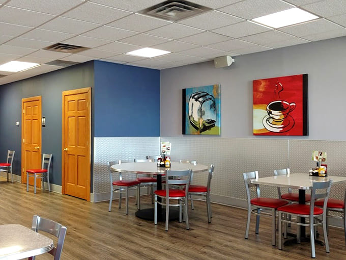 Bright red booths and colorful wall art create a cheerful vibe that says "sit down, relax, and prepare for sandwich greatness."