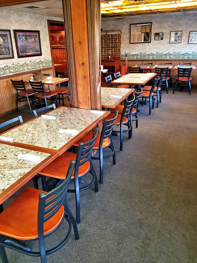 Marble-topped tables and wood-paneled walls create a timeless atmosphere where conversations flow as freely as the wine.