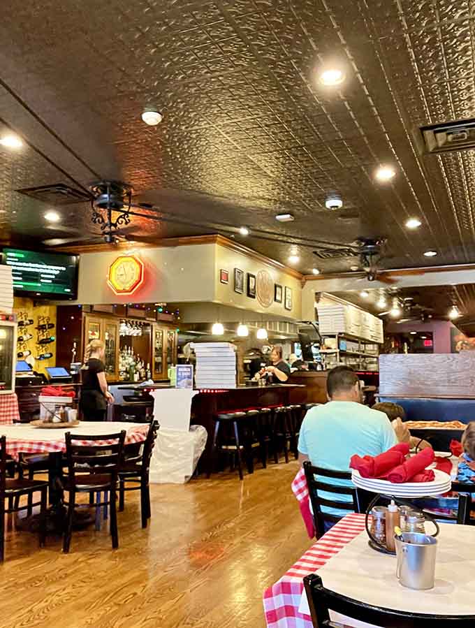 Tin ceilings and red-checkered tablecloths create an atmosphere where pizza dreams come deliciously true.