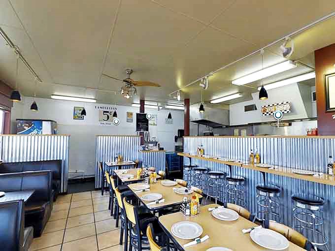 Classic diner vibes with corrugated metal wainscoting and cozy booths create that "everybody knows your name" atmosphere where comfort food meets comfort seating.
