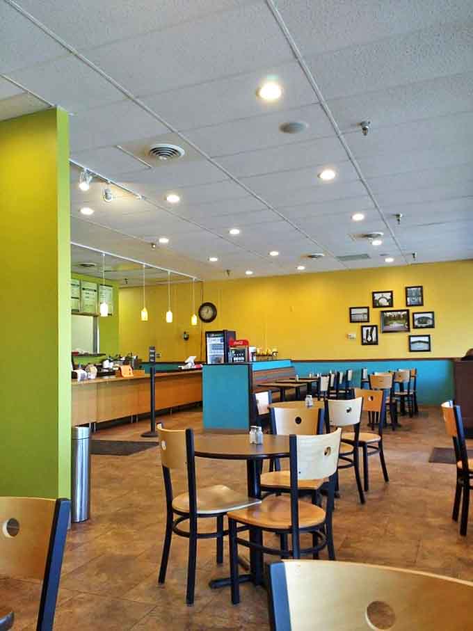 Interior charm on full display with sunny yellow walls and teal accents creating the perfect backdrop for comfort food indulgence.