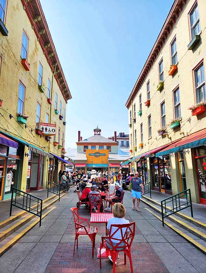 The market's central corridor transforms into a communal dining paradise, where red chairs invite strangers to become temporary friends over shared meals.