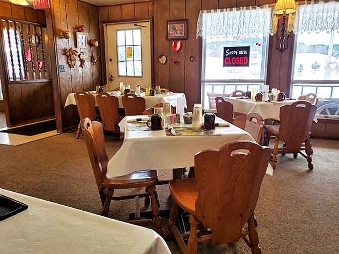 Wood-paneled walls and sturdy chairs create that perfect small-town diner atmosphere where conversations flow as freely as the coffee.