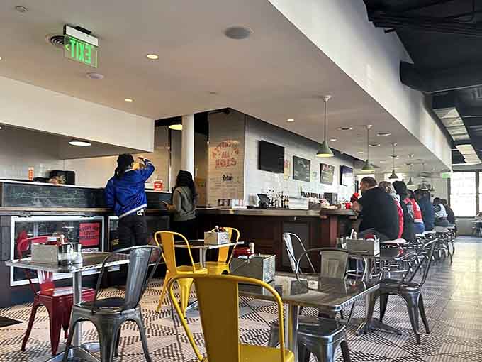 Industrial meets inviting: where exposed ceilings and colorful chairs create the perfect breakfast atmosphere.